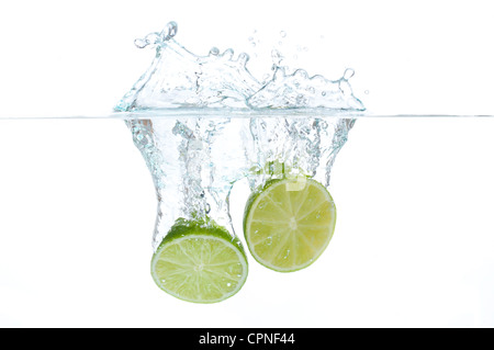 Lime Citrus Fruits splashing with bubbles into water isolated against ...