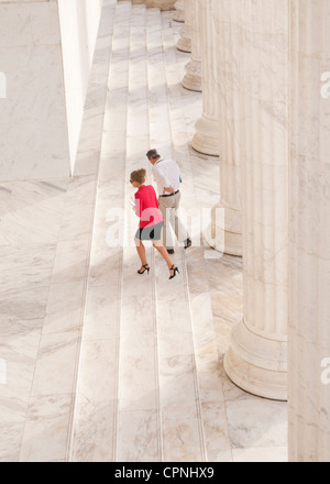 person climbing steps next to columns Stock Photo - Alamy