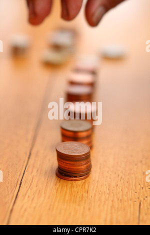 sterling 2p coins being sorted into small piles by an elderly person ...