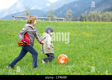 Boys chasing ball Stock Photo - Alamy