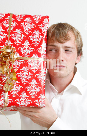 A man trying to guess a present Stock Photo - Alamy