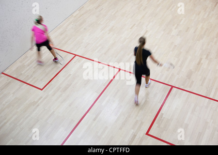 Two female squash players in fast action on a squash court (motion ...