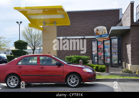Cars use a drive through window to order and pick up fast food at a ...