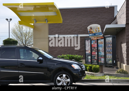 Cars use a drive through window to order and pick up fast food at a ...