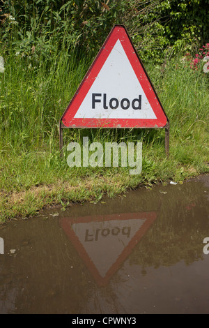 Flood warning sign reflected in flood water from the River Severn along ...