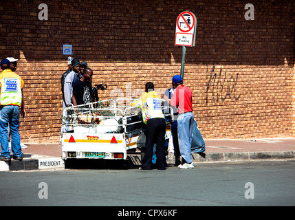 A South African JMPD police officer in riot gear holding police tape ...