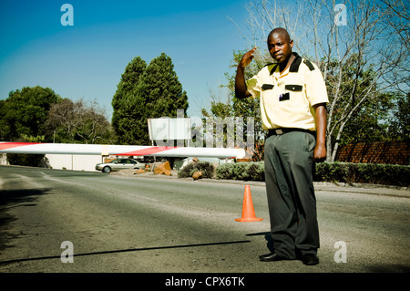 A security guard guarding a boom gate Stock Photo - Alamy