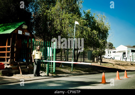 A security guard guarding a boom gate Stock Photo - Alamy