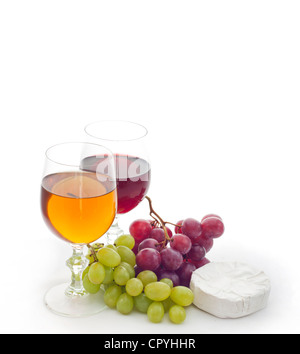 White and red wine glasses and grape on old stone table with copy space ...