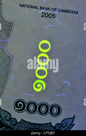 Banknote in ultraviolet light showing otherwise invisible security ...