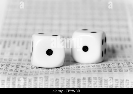 Two dice on a chart with stock prices Stock Photo - Alamy