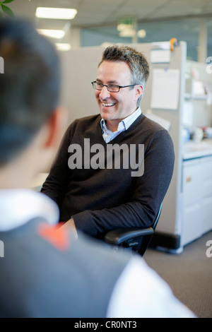 Business people talking over cubicle wall Stock Photo - Alamy
