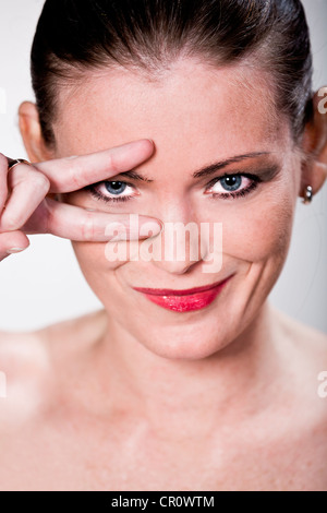 Mischievous attractive cheeky young woman sticking out her tongue at ...