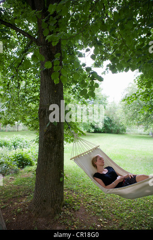 woman laying down in hammock in the forest tent on background copy ...