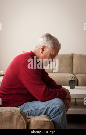 Worried senior man sitting by the side of the bed in the night unable ...