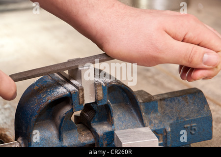 Grinding a block of metal with a file Stock Photo - Alamy