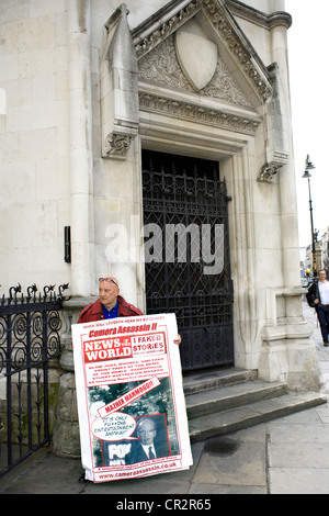 Former News of the World photographer Ian Cutler demonstrates during ...