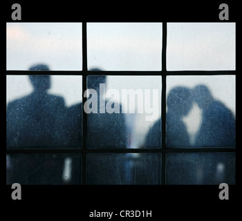 Four silhouettes of people behind of a window Stock Photo - Alamy