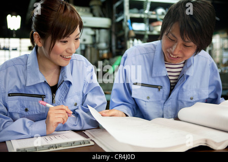 Two Factory Workers Reading Documents Stock Photo - Alamy