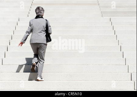 older woman going up the stairs at home arriving house Stock Photo - Alamy