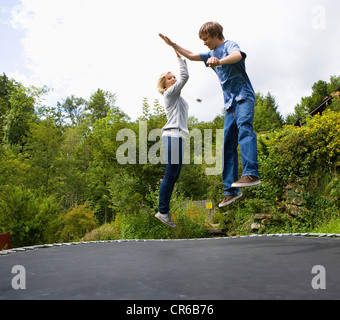 Young caucasian man jumping high over the clouds with clear blue sky in ...