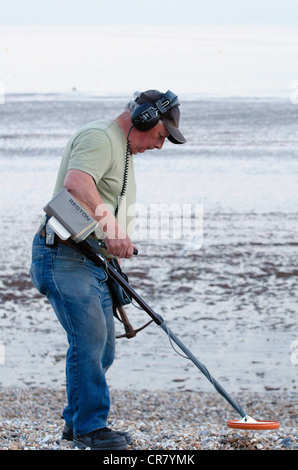 a person using a metal detector to look for coins Stock Photo - Alamy