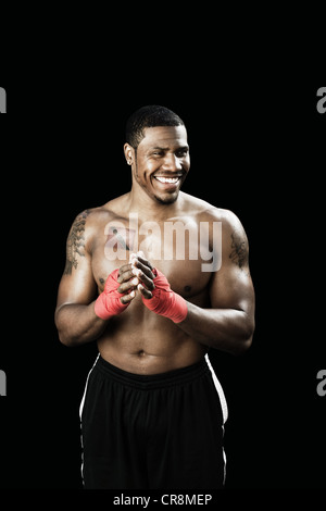 Front view of muscular black boxer punching towards camera with a deep ...