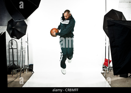 Creative studio shot of basketball player in studio using colored gels ...