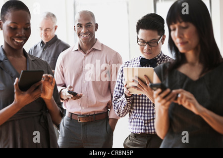Businesspeople using handheld computers and digital tablets Stock Photo ...