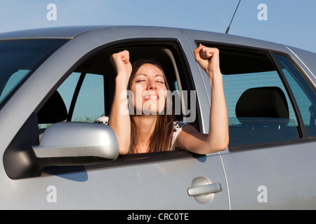 Happy car owners. Beautiful young couple sitting at the front seats of ...