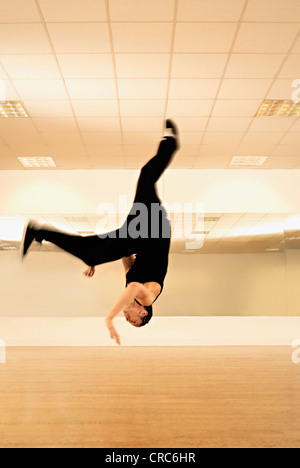Male dancer flipping mid-air, body twisting with vibrant energy ...