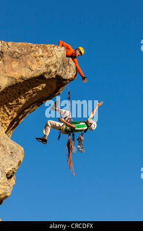 Climbing team struggle to the summit of a challenging rock mountain ...