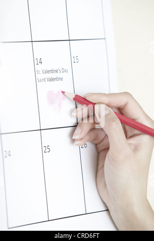 Woman hand drawing heart shape on a calendar Stock Photo - Alamy