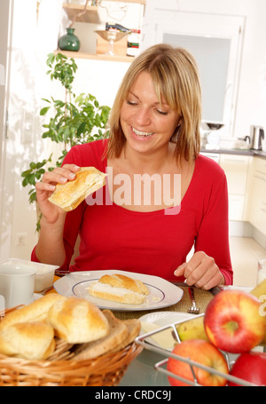 Having a breakfast by eating cookies. Cute little girl in casual ...