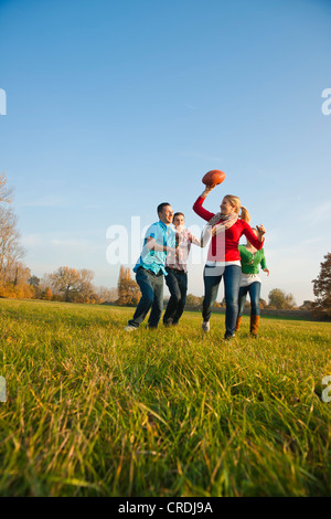 Group of young people playing with ball at the beach. Young friends ...