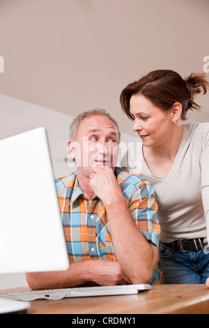 Couple in front of a computer Stock Photo - Alamy