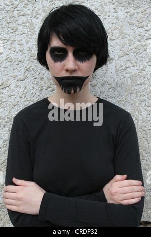 Goth teen girl in black clothes holding favorite boo in hands while ...