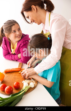 Happy mother and two girls having fun in a spinning tea cup ride at the ...