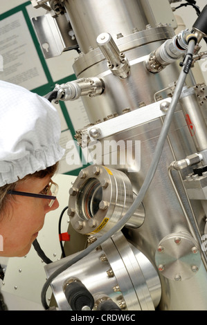 Female scientist laboratory assistant looks at a petri dish with ...