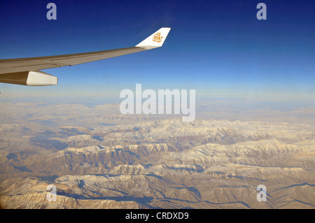 Wing of a flying Airbus 330-200 of the airline "Emirates" and blue sky ...