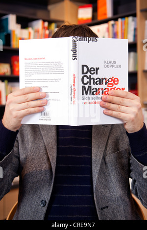 People read books at a bookstore covered with golden ginkgo leaves in ...
