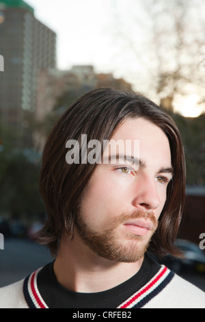 Young handsome man with long hair wearing santa claus hat over isolated ...
