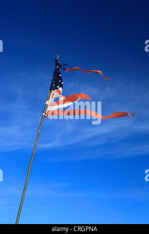 Tattered American flag blowing in the wind Stock Photo - Alamy