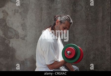 man lifting dumbbell over a grunge background Stock Photo - Alamy