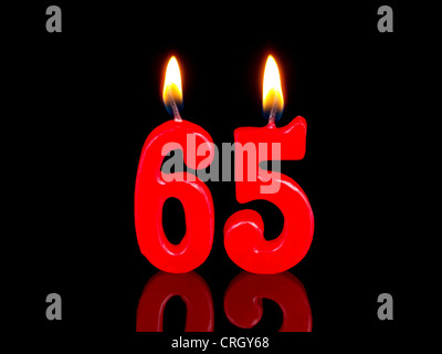 Number 65 birthday celebration candle against a bright yellow ...