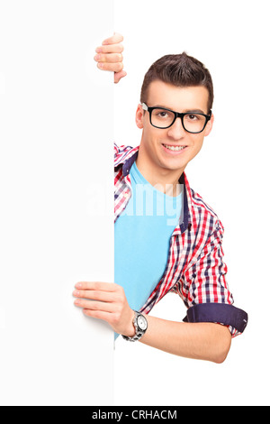 A smiling handsome male posing behind a white panel isolated stock ...