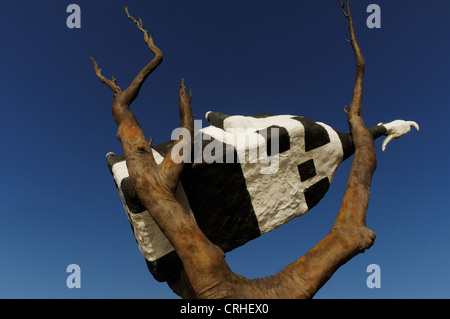 Cow up a tree by John Kelly in Melbourne's Docklands Stock Photo - Alamy