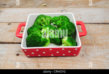 Broccoli in red porcelain tray on wooden table Stock Photo - Alamy