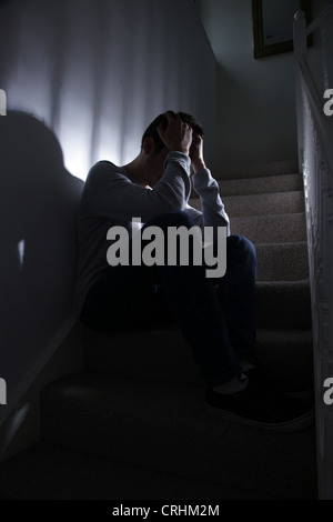 Young Depressed Man Slumped in Corner of Darkened Room Stock Photo - Alamy