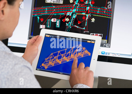 Engineer using iPad Computer Aided Design CAD application to model 3D design of complex ...